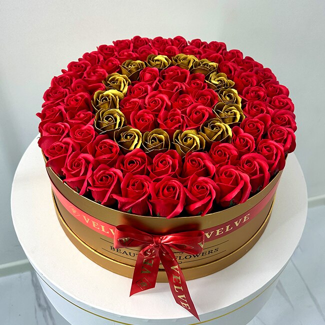 Aranjament floral personalizat cu litera O, in cutie rotunda aurie cu 75 trandafiri de sapun ...