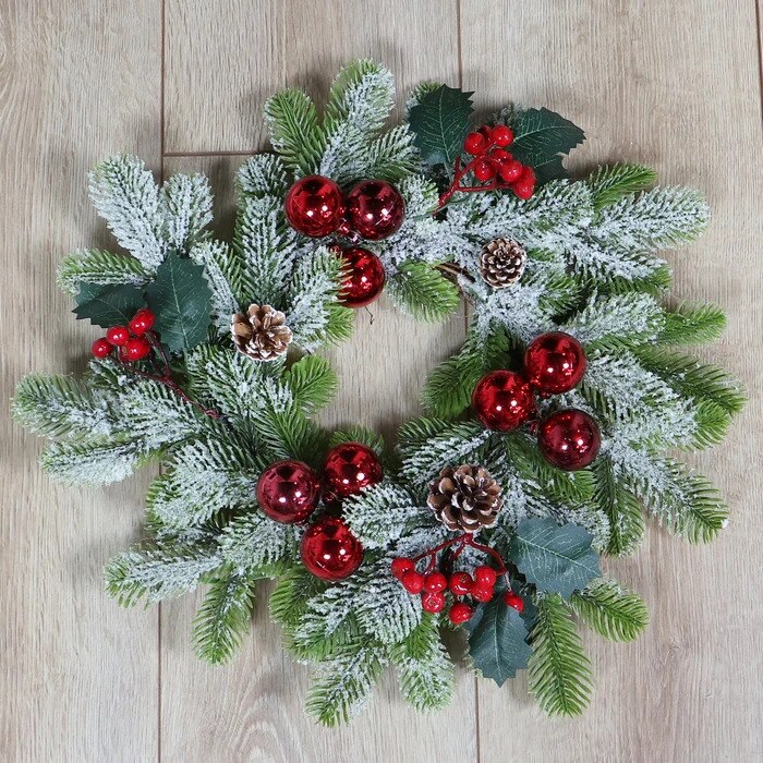 Коледен венец, украсен с елхови клонки със сняг по тях, червени плодове ...