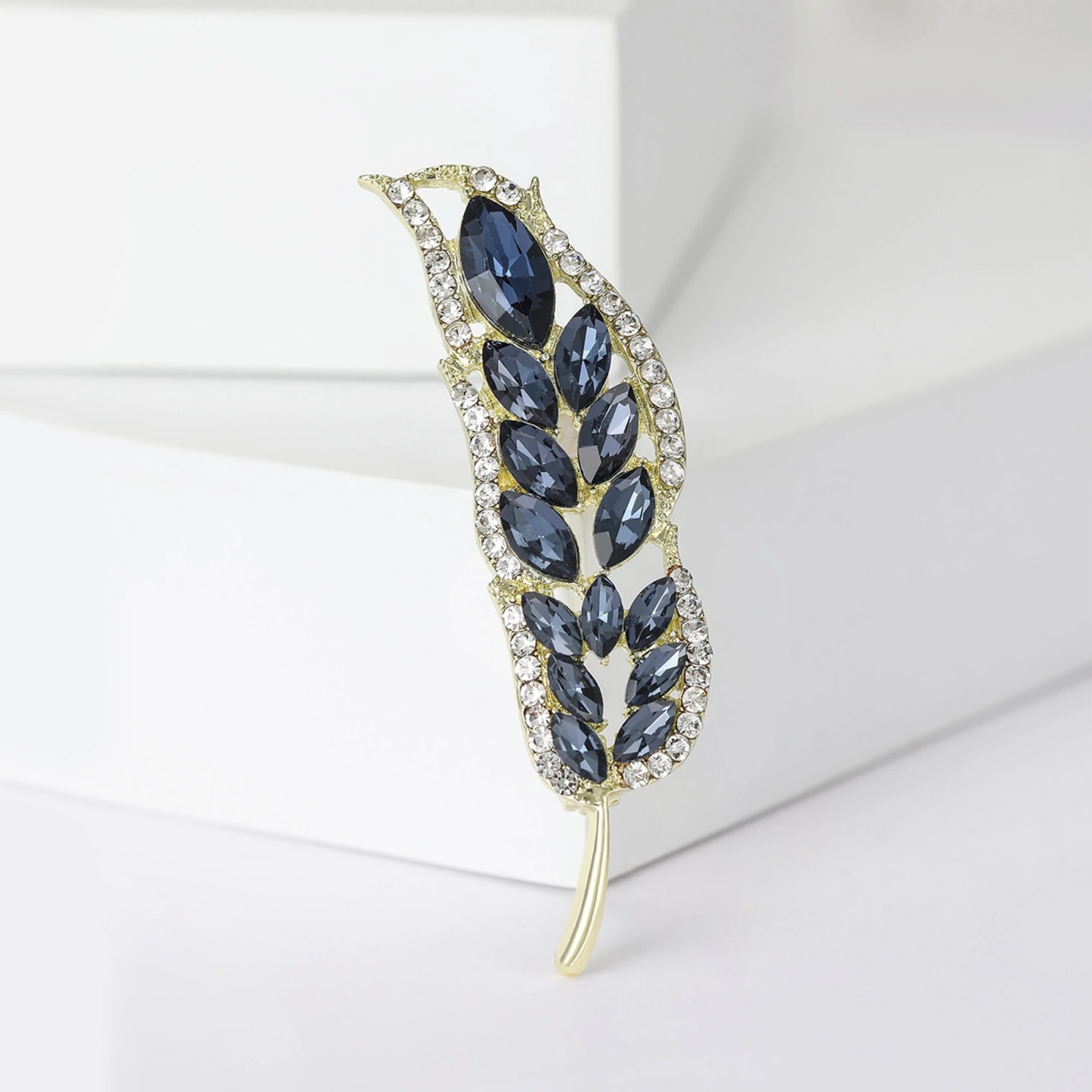 Brosa albastra, cu montura aurie, in forma de frunza, decorata cu ...